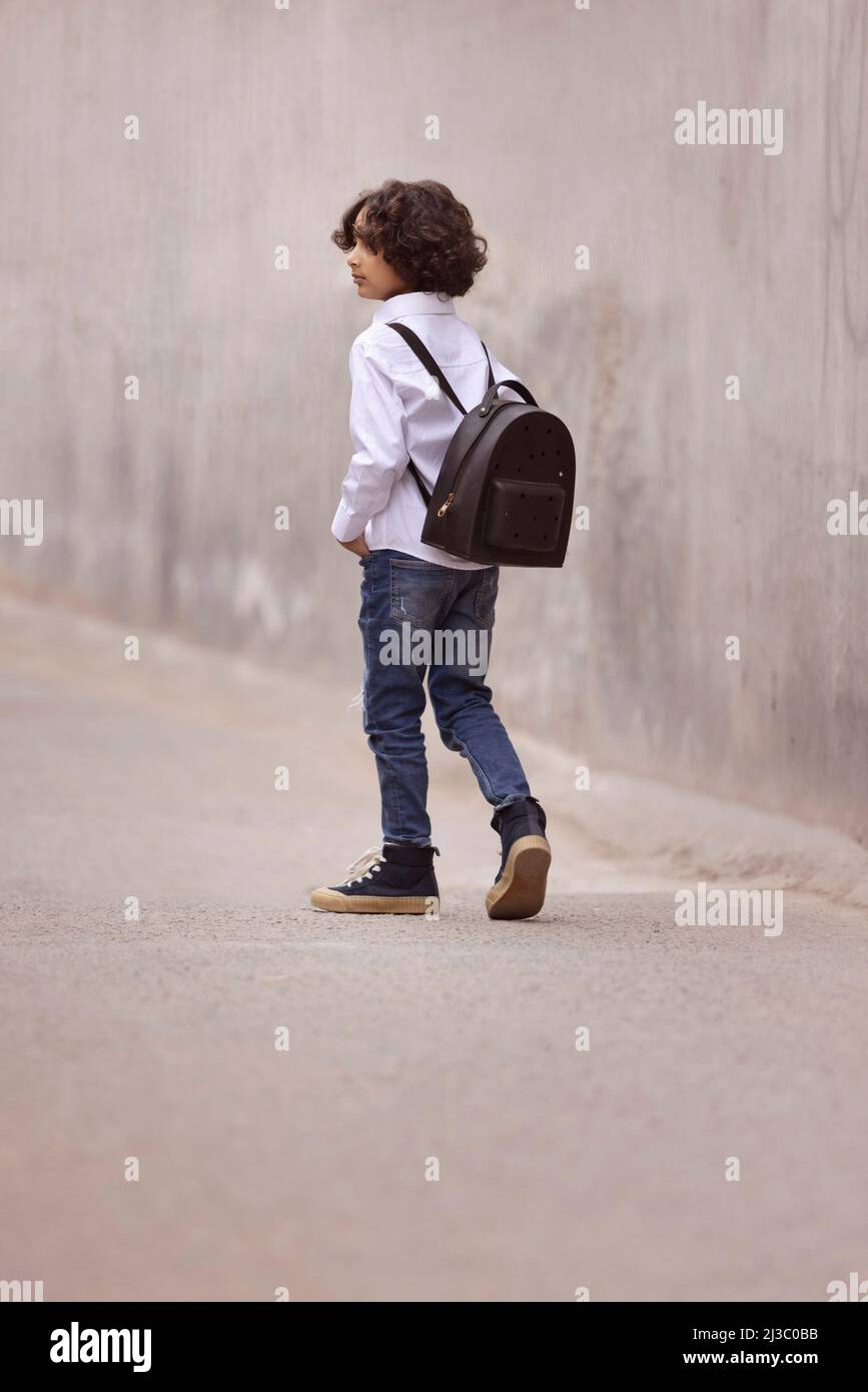 Back view of little school boy walking down the street to school Stock ...