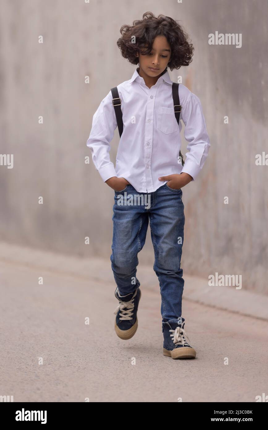 Little boy in school uniform walking down the street to school Stock ...