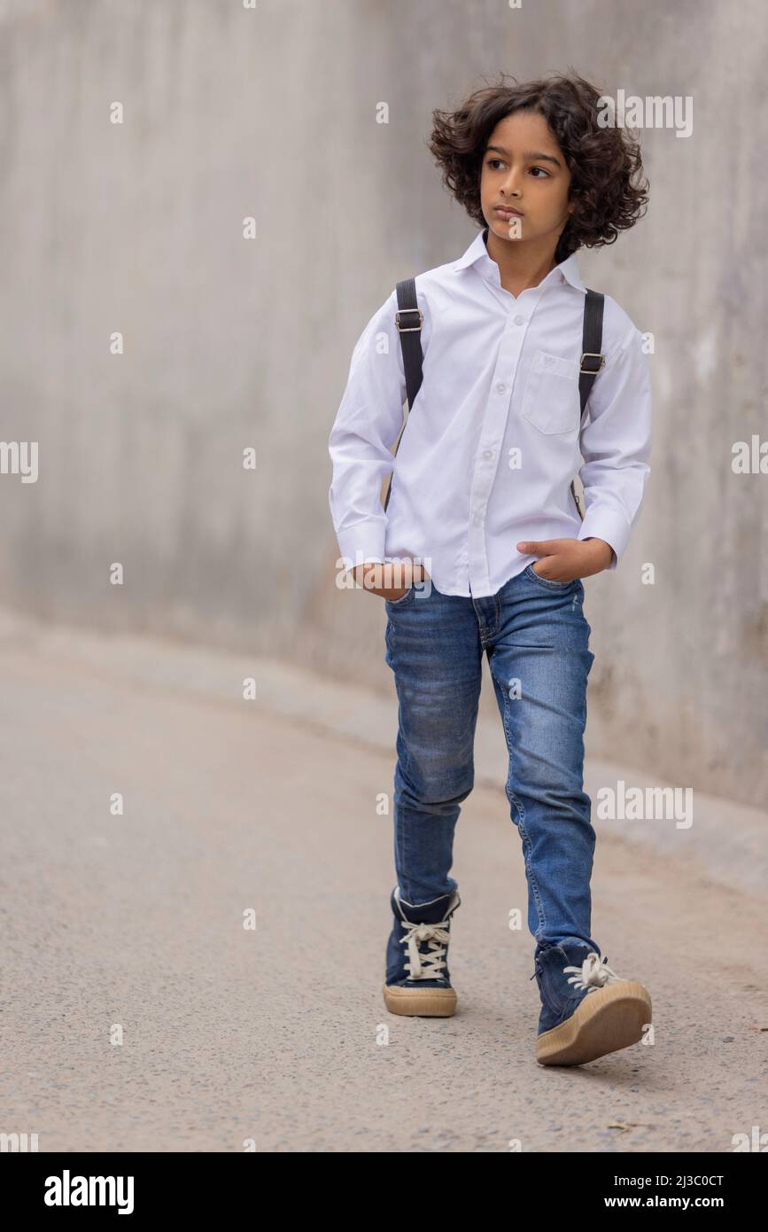 Little boy in school uniform walking down the street to school Stock ...