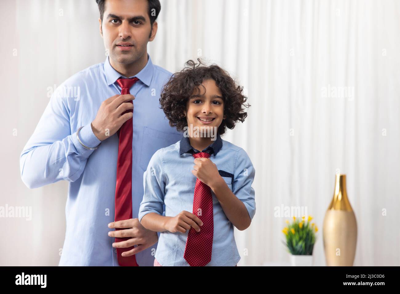 Father and son wearing ties together in front of mirror Stock Photo - Alamy