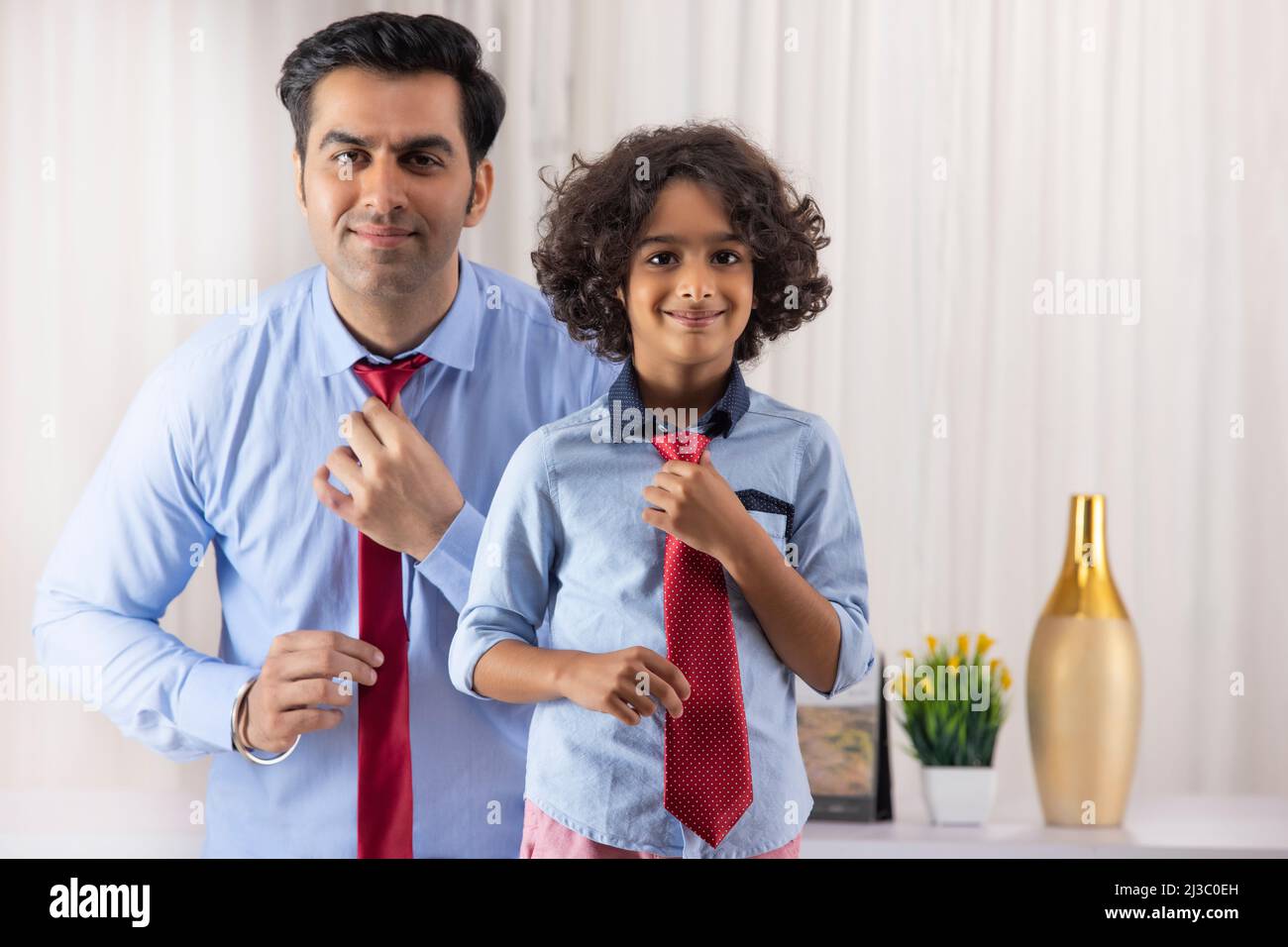 Father and son wearing ties together in front of mirror Stock Photo - Alamy
