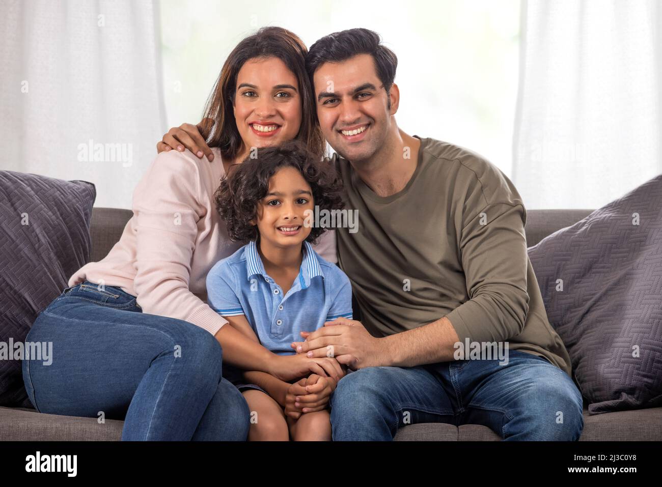 Portrait of a happy parent with kid looking together at camera with ...