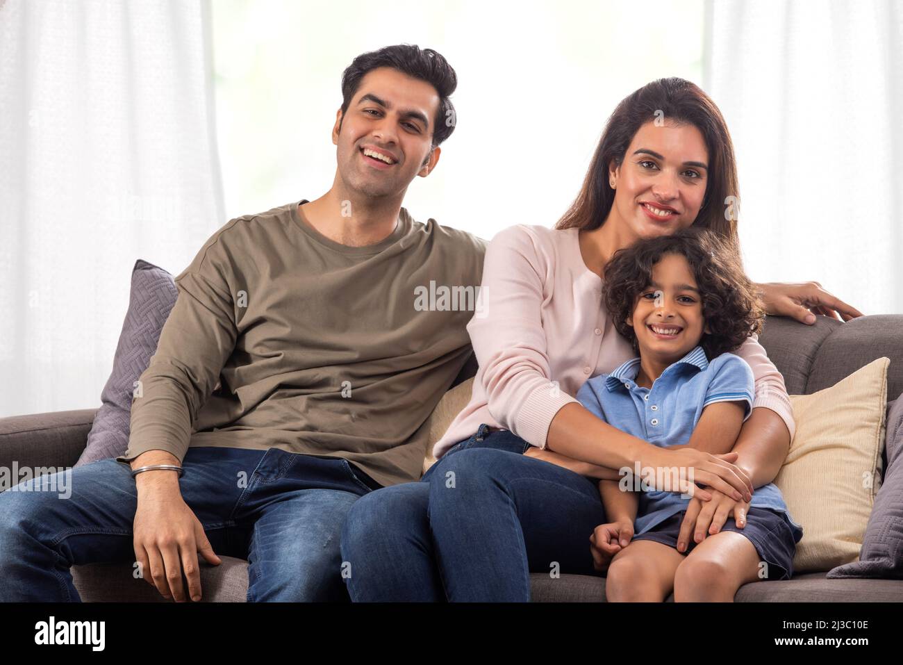 Portrait of a happy parent with kid looking together at camera with ...