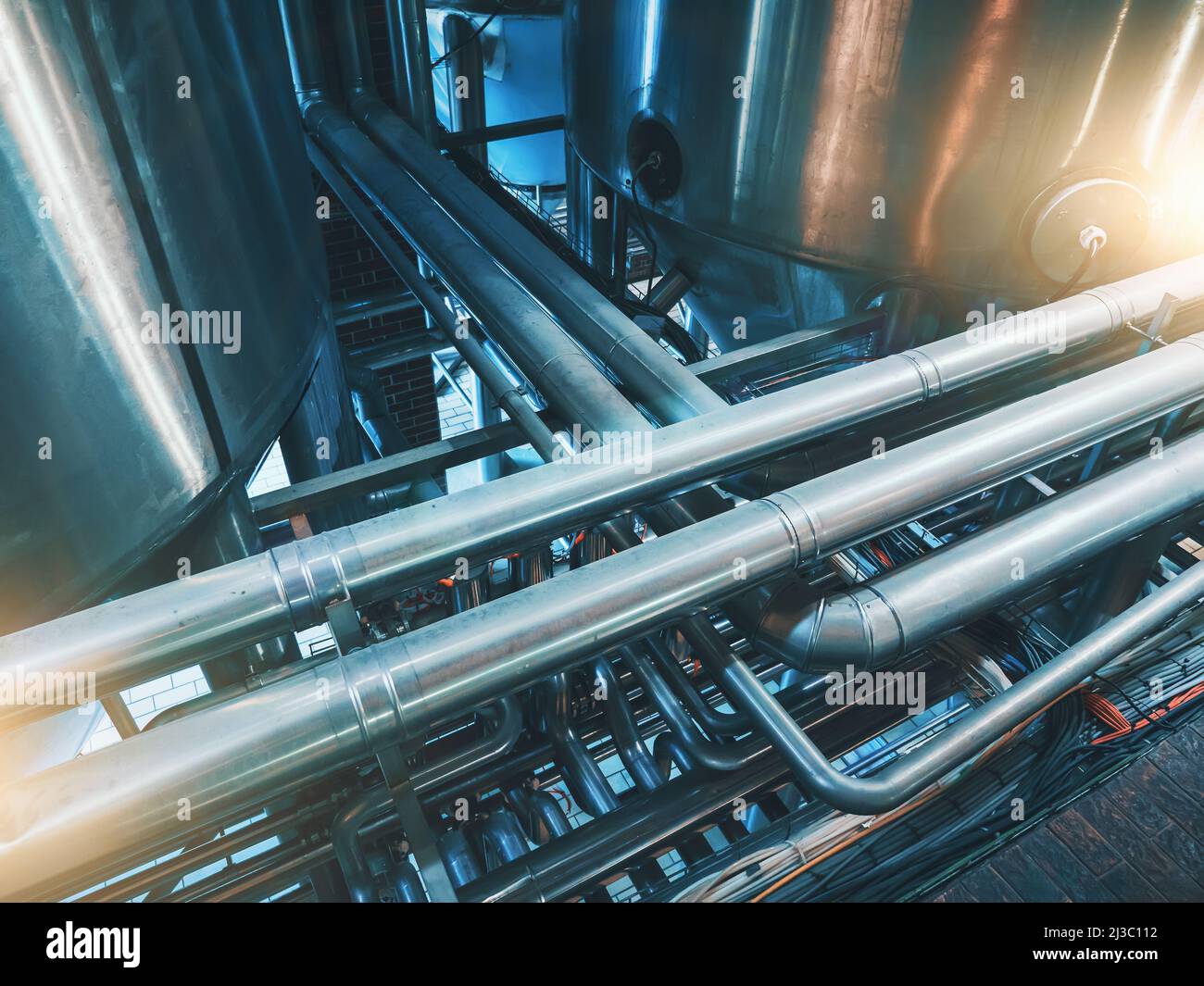 Large steel tanks and pipes. Industrial brewery factory pipelines in ...