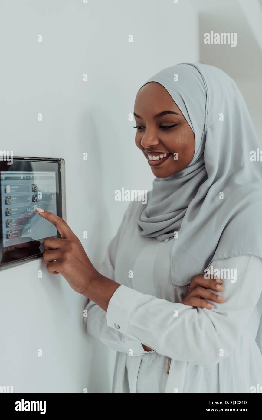 African woman using smart home screen control system Stock Photo - Alamy