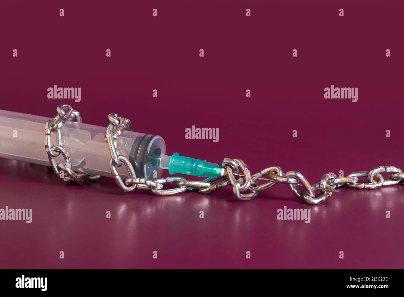 Drug addiction. An empty medical syringe is wrapped with a chain Stock ...