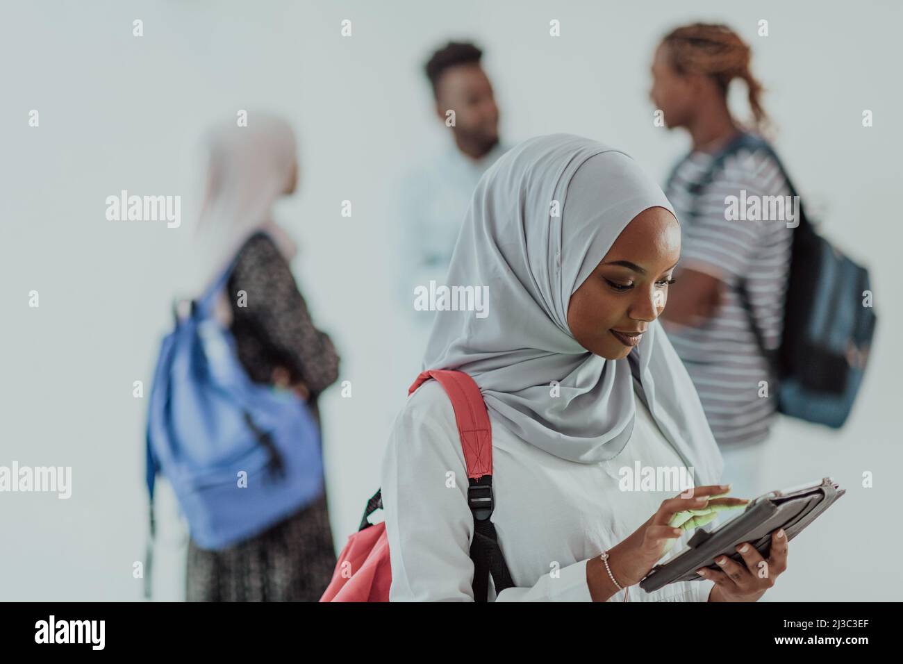 African female student with group of friends in background wearing ...