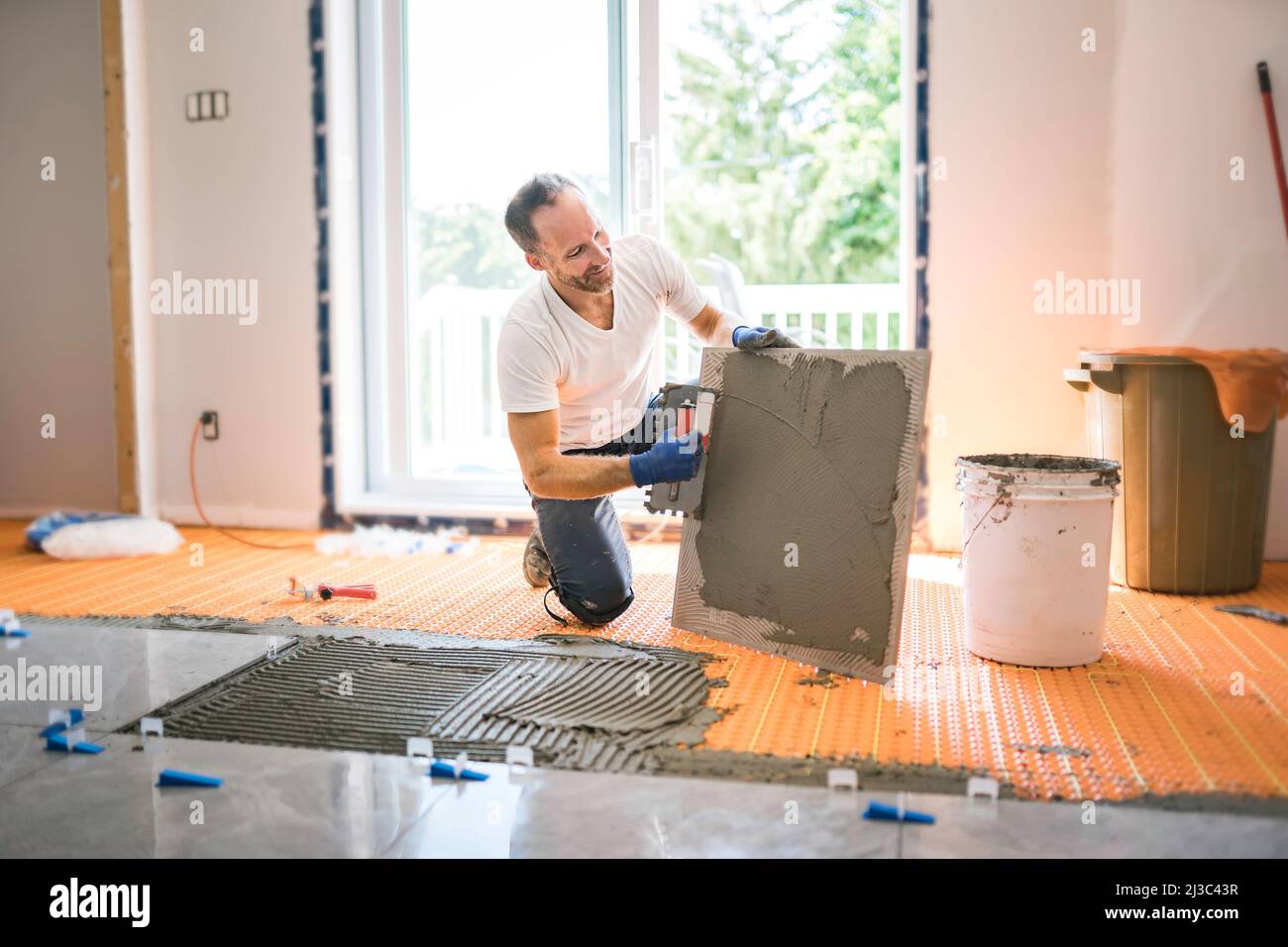 nice handyman install tile on the floor Stock Photo - Alamy