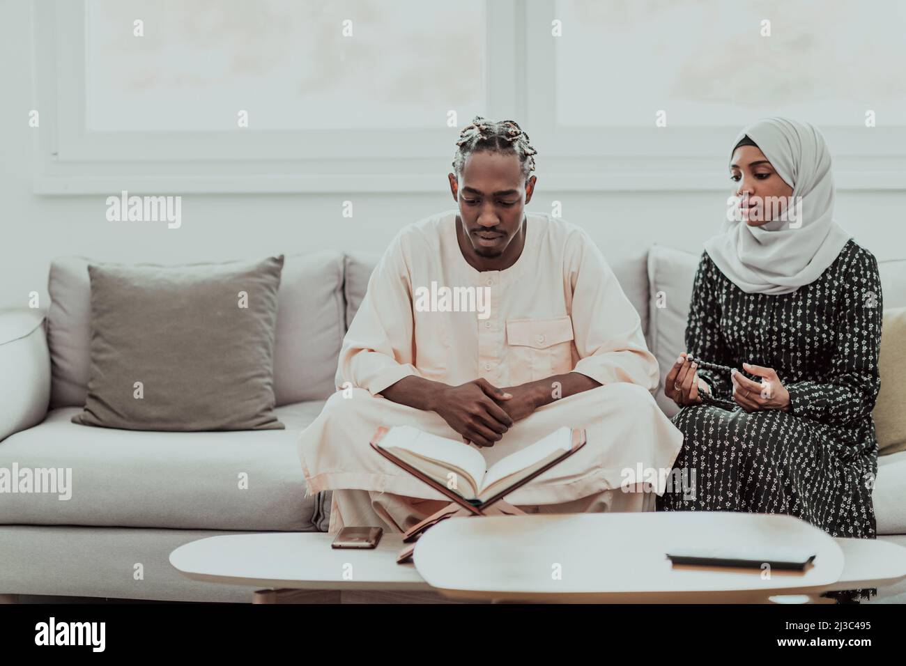 African Muslim couple at home in Ramadan reading Quran holly Islam book ...