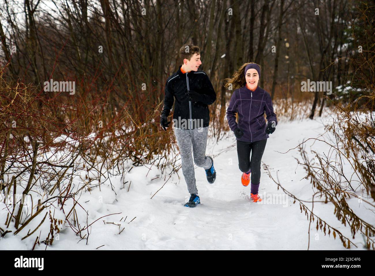 two twin brother and sister running in winter forest Stock Photo - Alamy