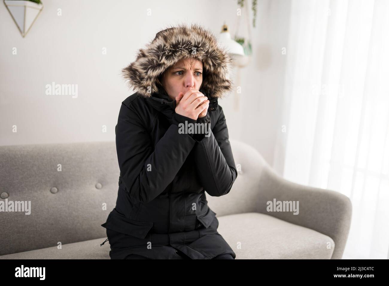 Woman With Warm Clothing Feeling The Cold Inside House on the sofa ...