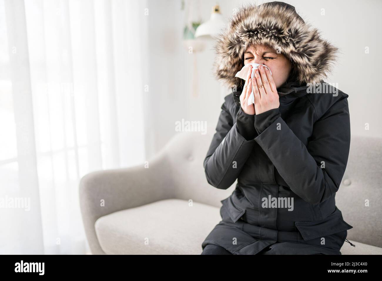 Woman With Warm Clothing Feeling The Cold Inside House on the sofa she ...