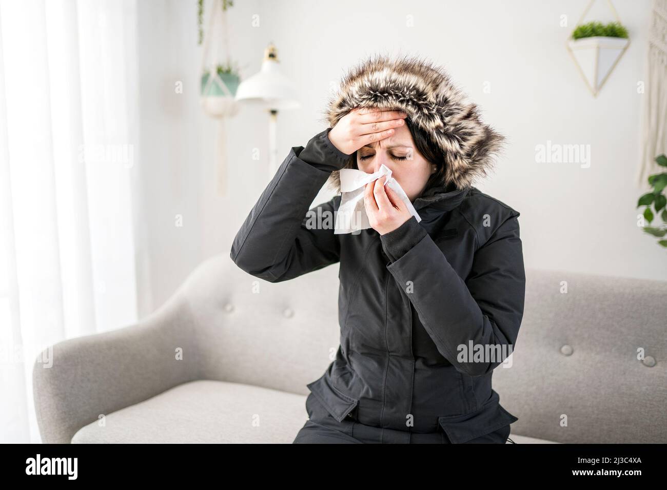Woman With Warm Clothing Feeling The Cold Inside House on the sofa she ...