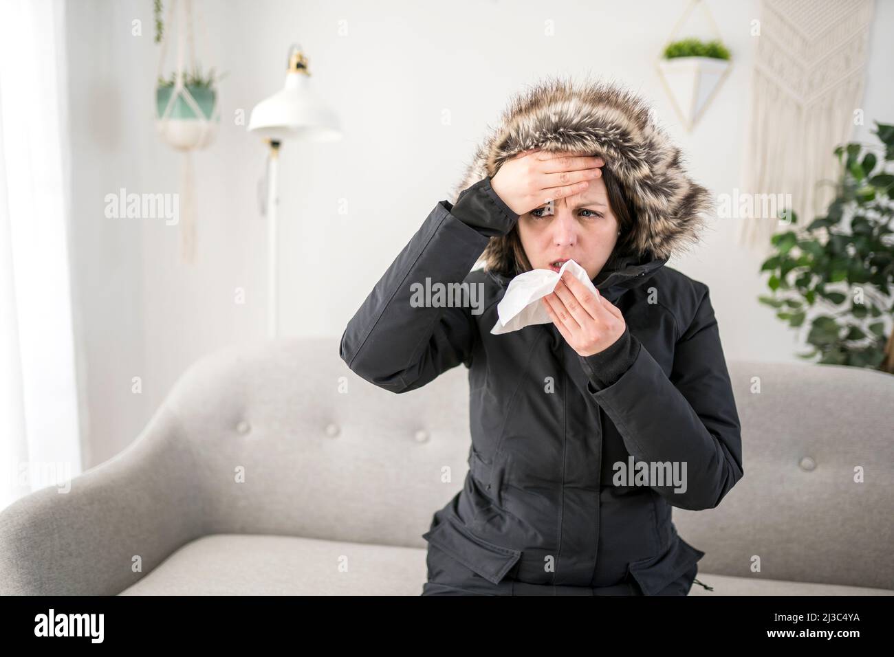 Woman With Warm Clothing Feeling The Cold Inside House on the sofa she ...