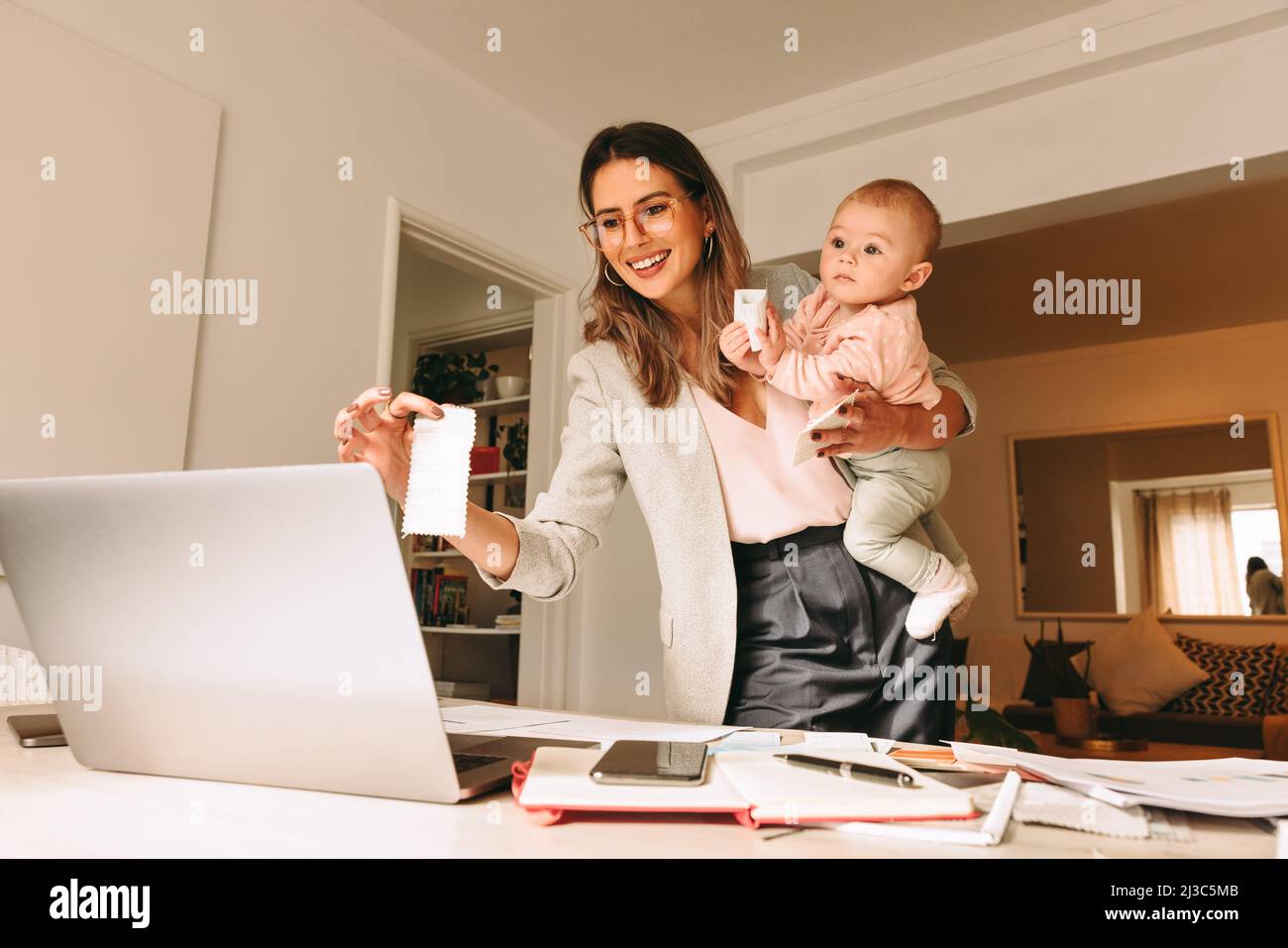Happy working mom holding a fabric swatch during a video call. Cheerful ...