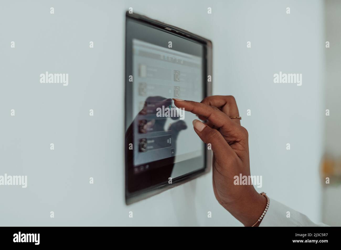 African woman using smart home screen control system Stock Photo - Alamy