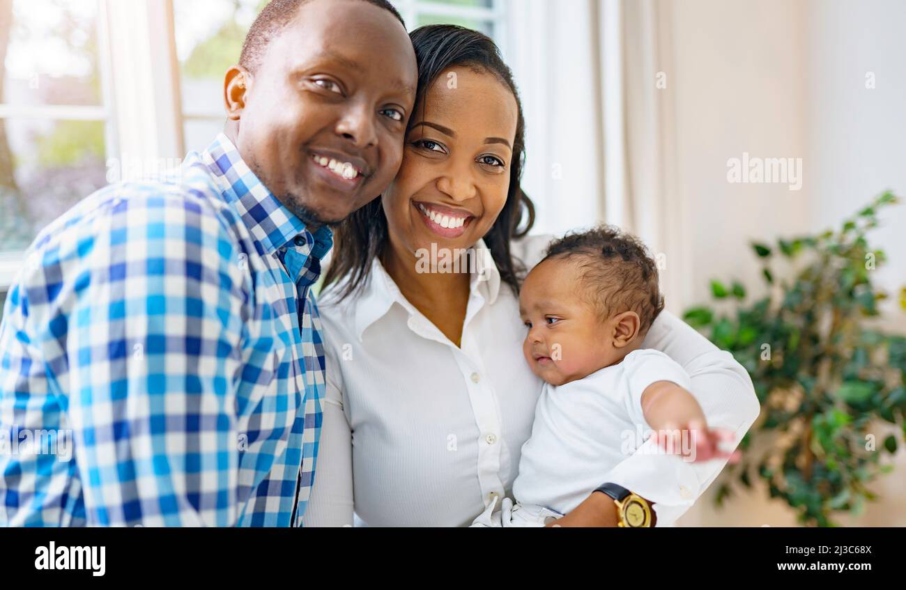 Happy parents with baby boy at home in the bedroom Stock Photo - Alamy
