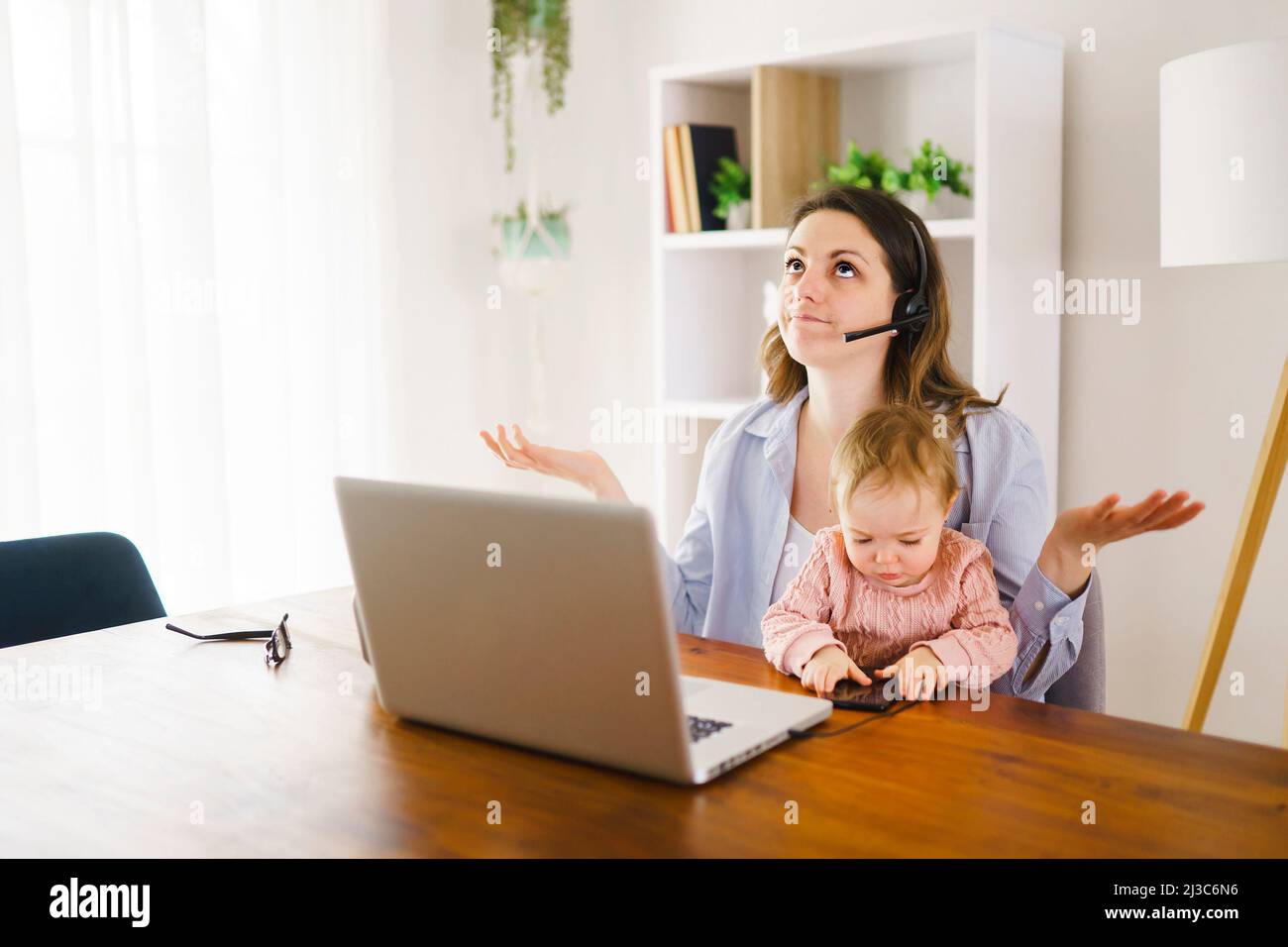 sad and frustrated mother in kitchen home office with computer and her ...