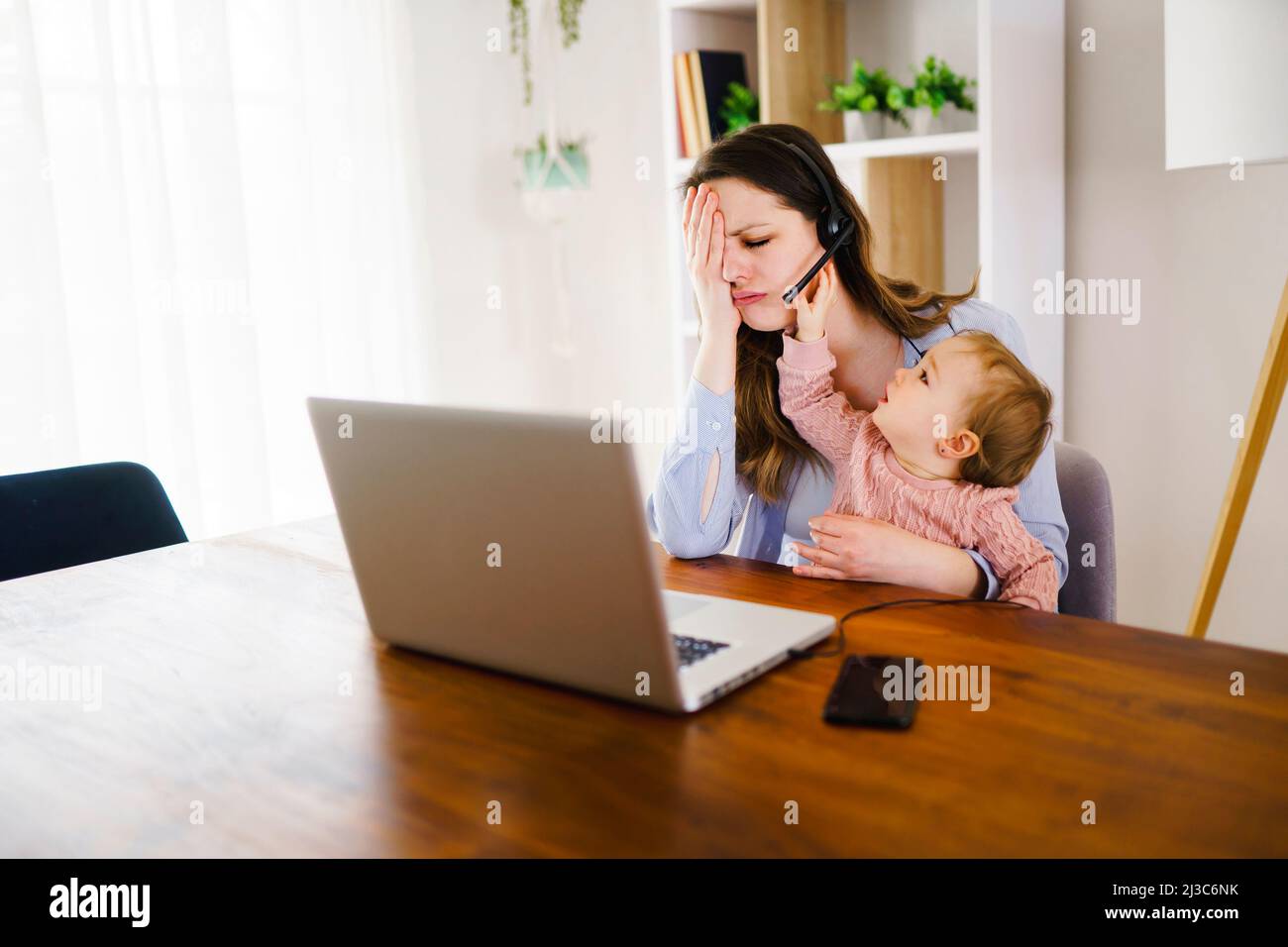 sad and frustrated mother in kitchen home office with computer and her ...