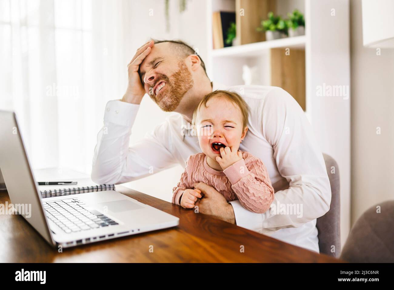 sad and frustrated father in kitchen home office with computer and her ...