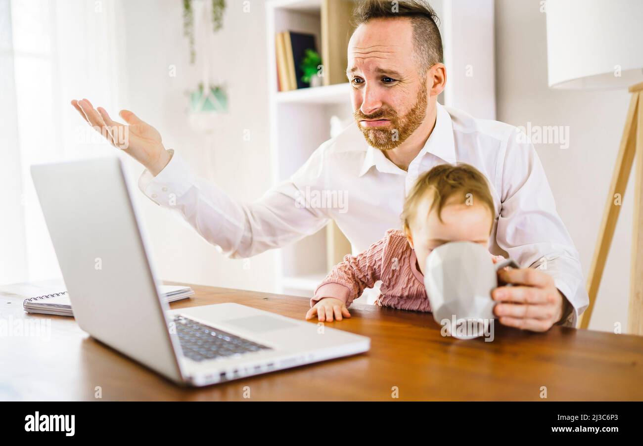 sad and frustrated father in kitchen home office with computer and her ...