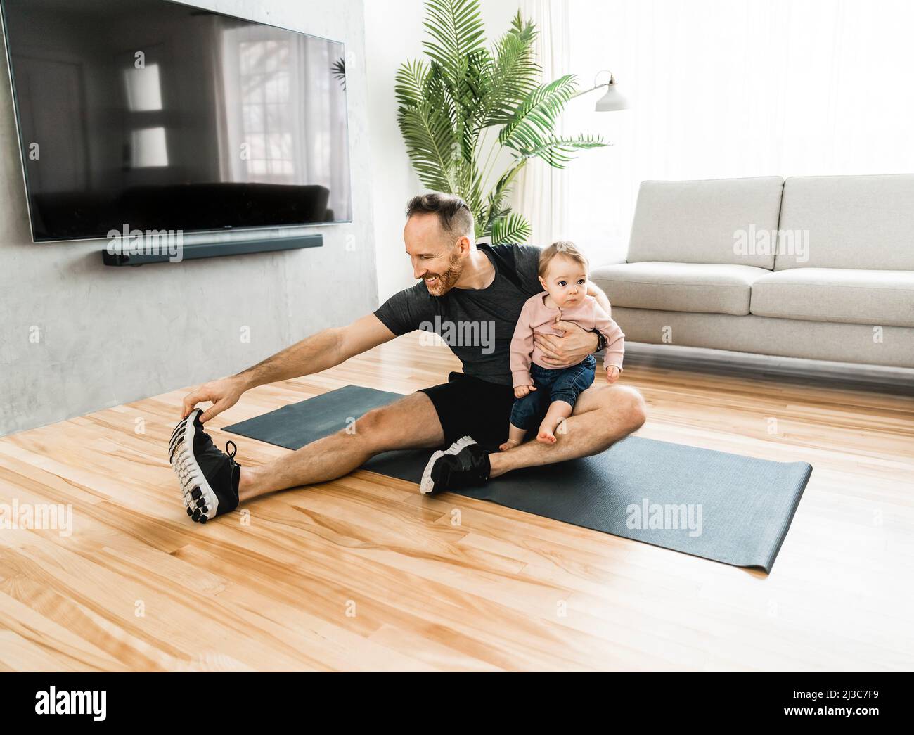 Nice father training with his baby at home Stock Photo - Alamy
