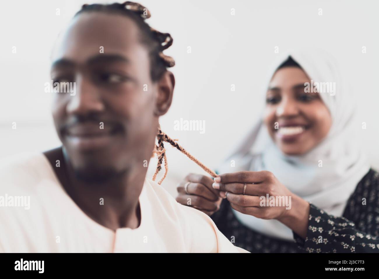 A young Muslim couple has a romantic time at home while the woman makes ...