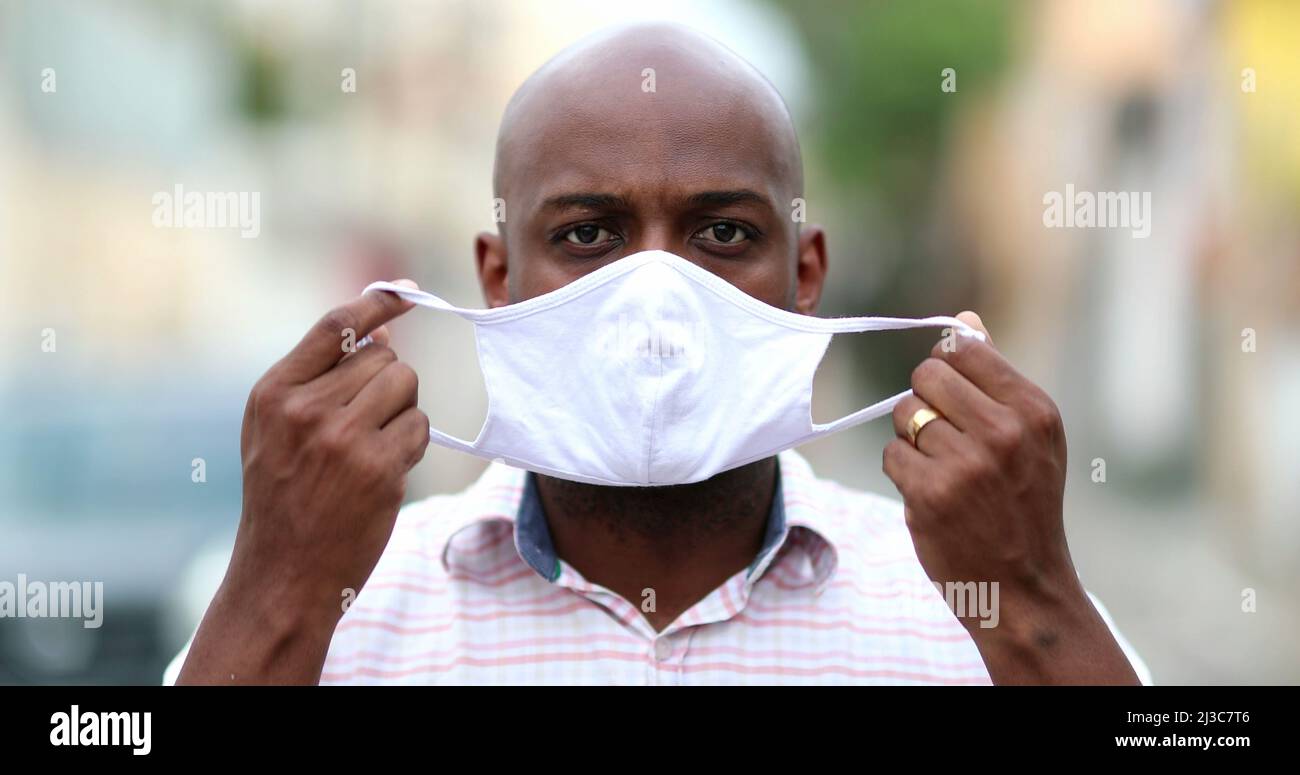 African man removing face mask feeling relief, black guy takes off ...