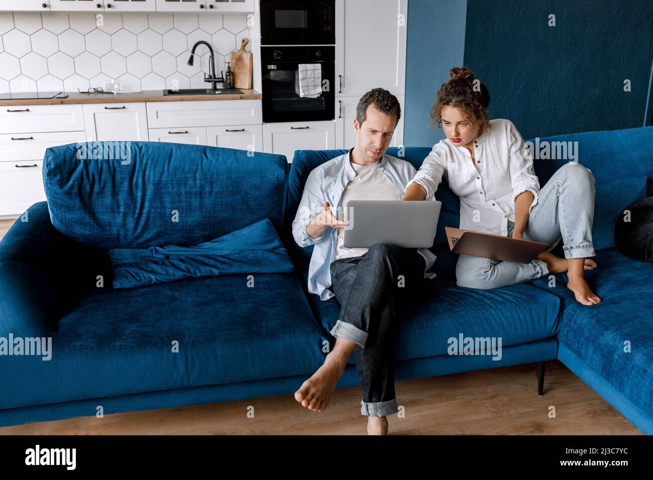 Image of successful young couple man and woman working on laptops ...