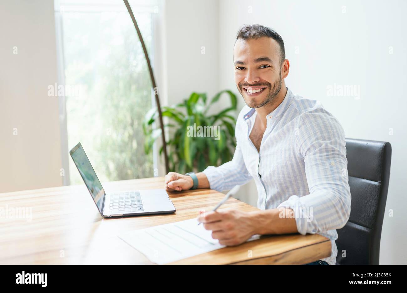 Portrait young mexican attractive businessman working at modern home ...
