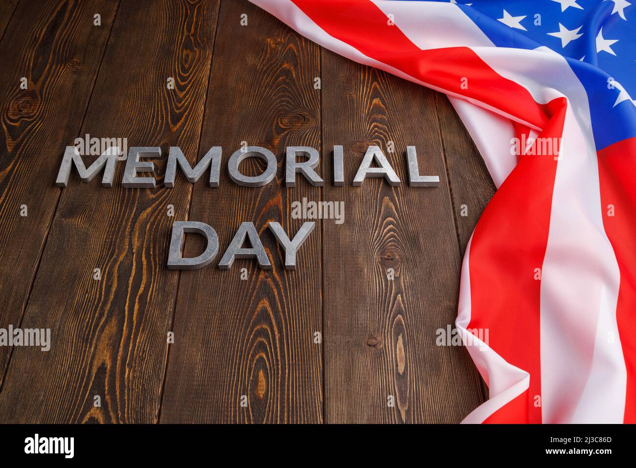 the words memorial day laid with silver metal letters on wooden board ...
