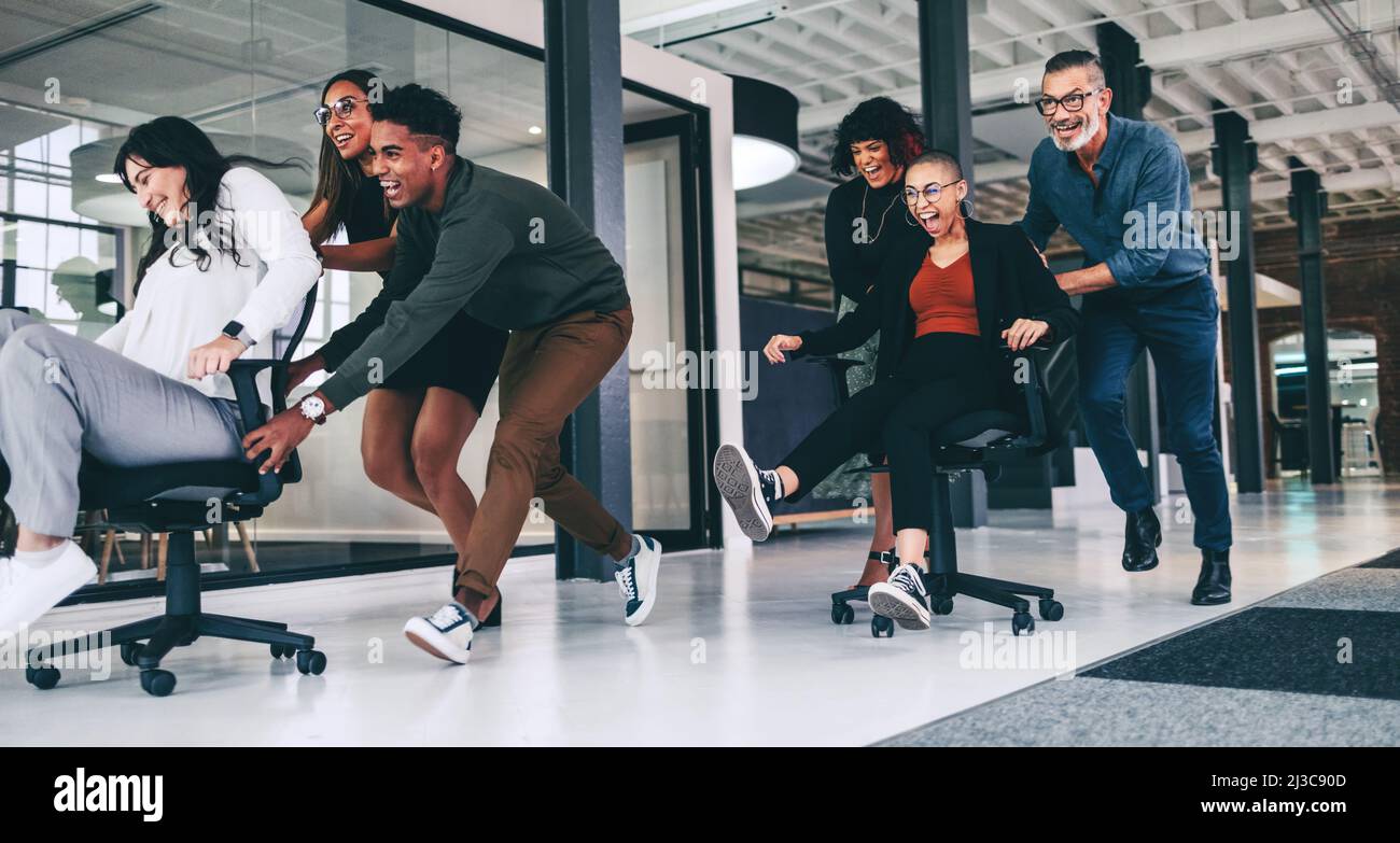 Cheerful coworkers enjoying playtime together at work. Happy group of ...
