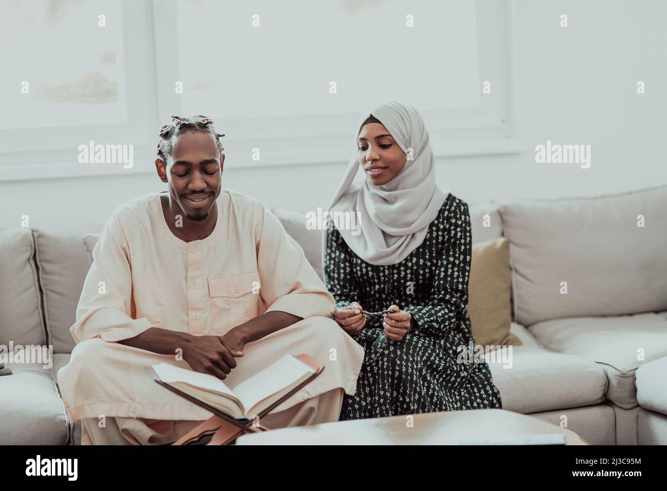 African Muslim couple at home in Ramadan reading Quran holly Islam book ...