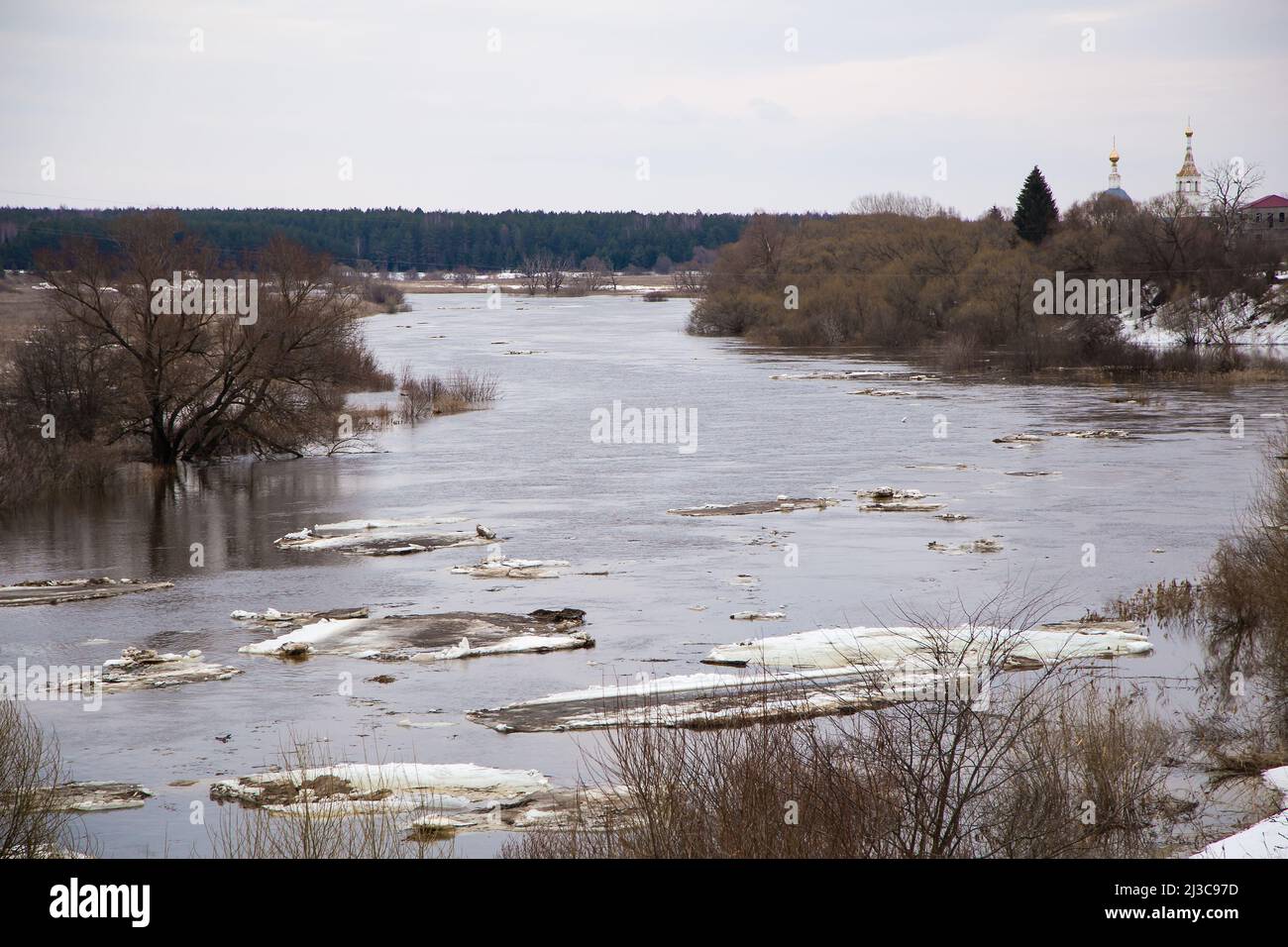 Slowly, small ice floes float down the river. Spring, snow melts, dry ...
