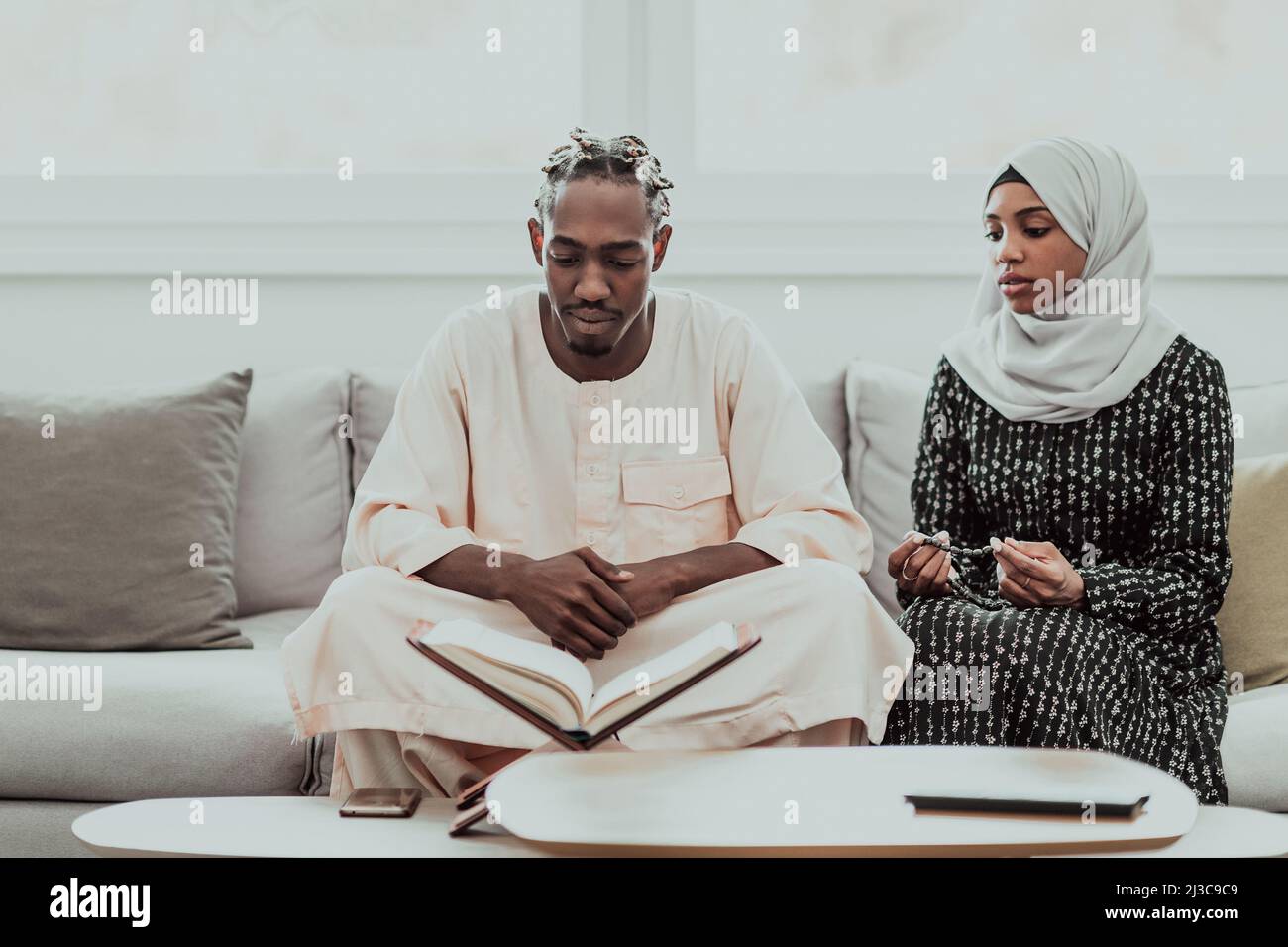 African Muslim couple at home in Ramadan reading Quran holly Islam book ...