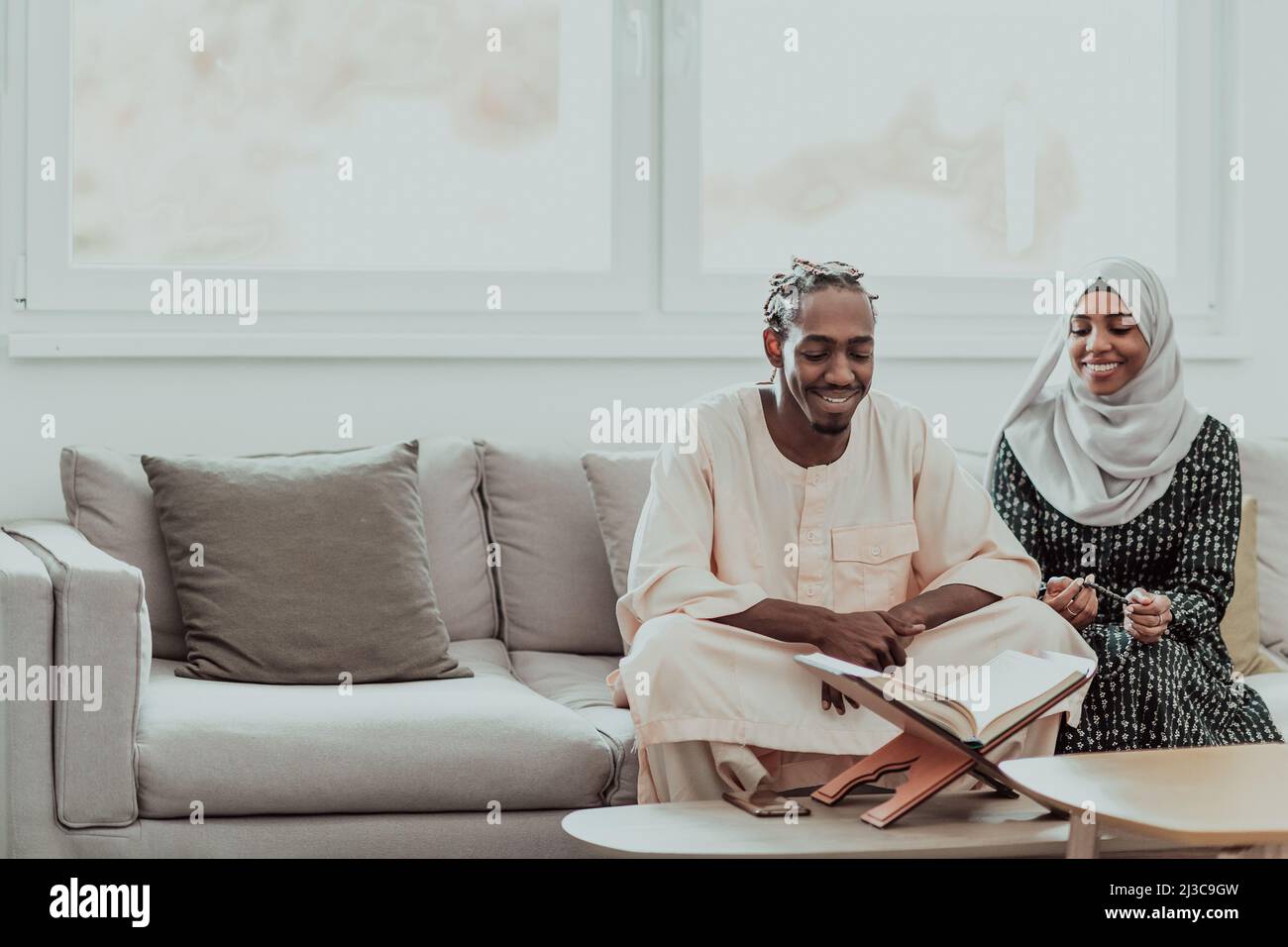 African Muslim couple at home in Ramadan reading Quran holly Islam book ...