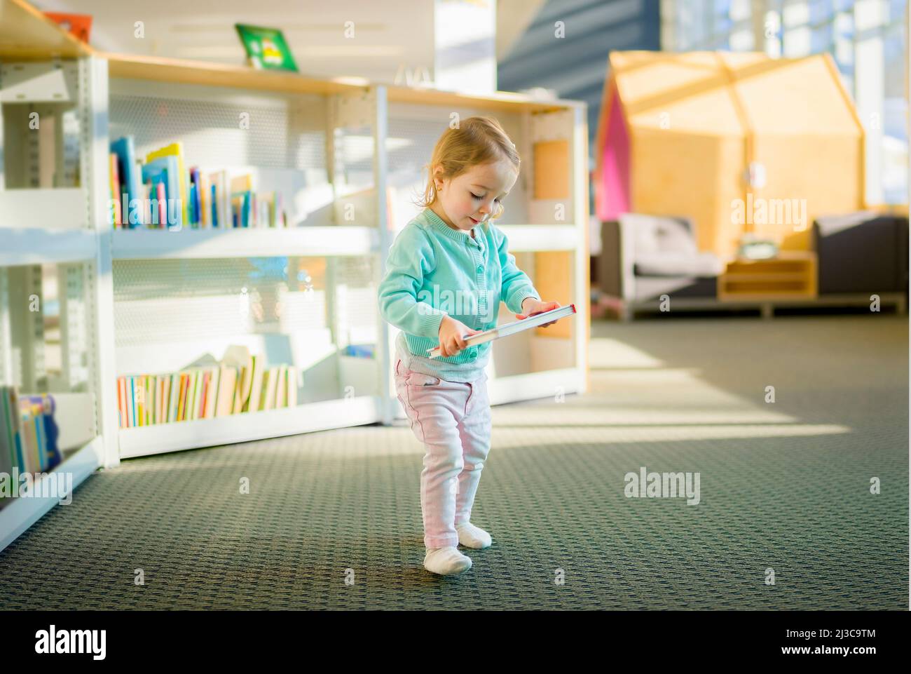 Little Girl holding Books at the Library Stock Photo - Alamy