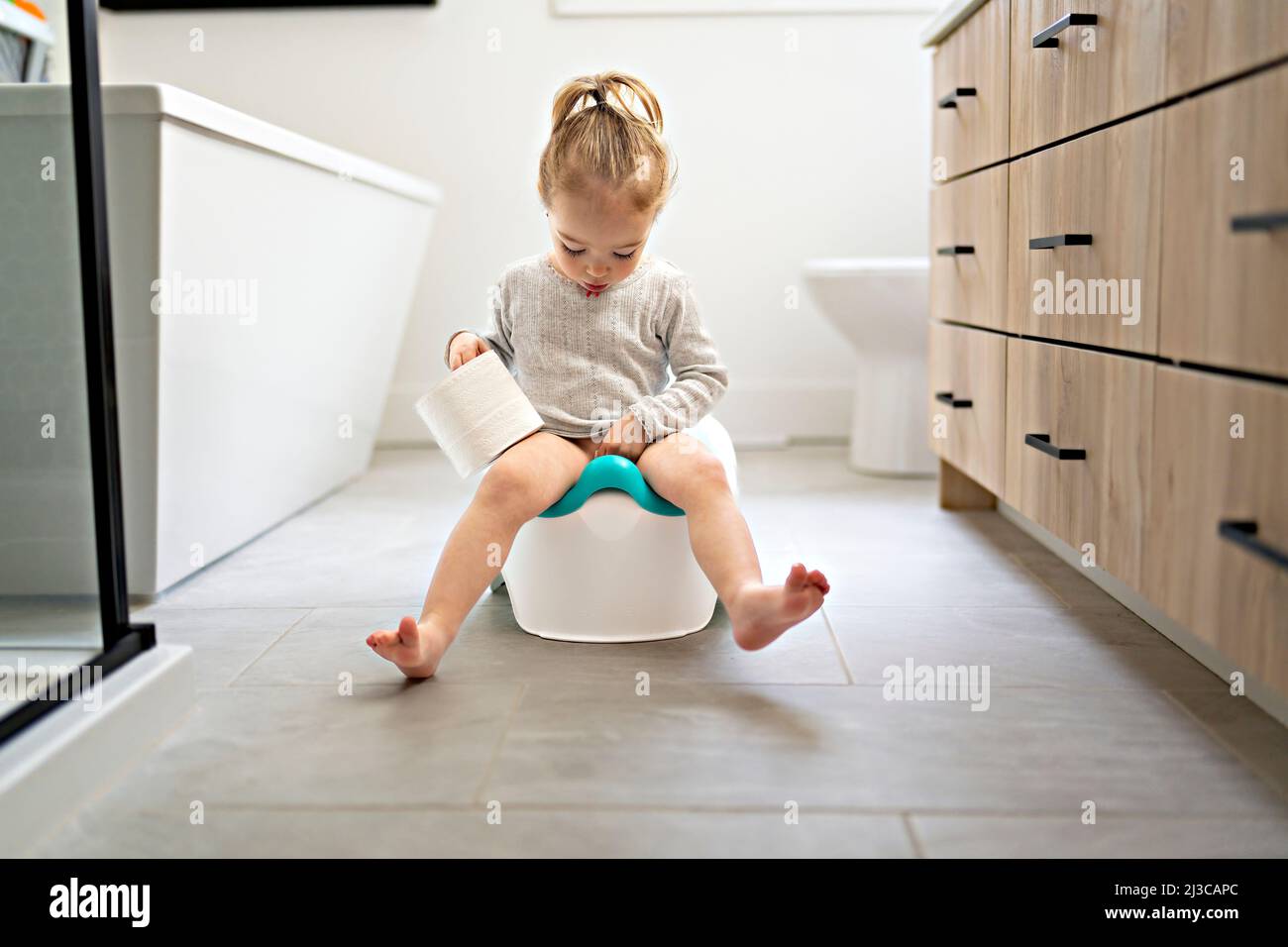 Adorable young baby child sitting and learning how to use the toilet ...