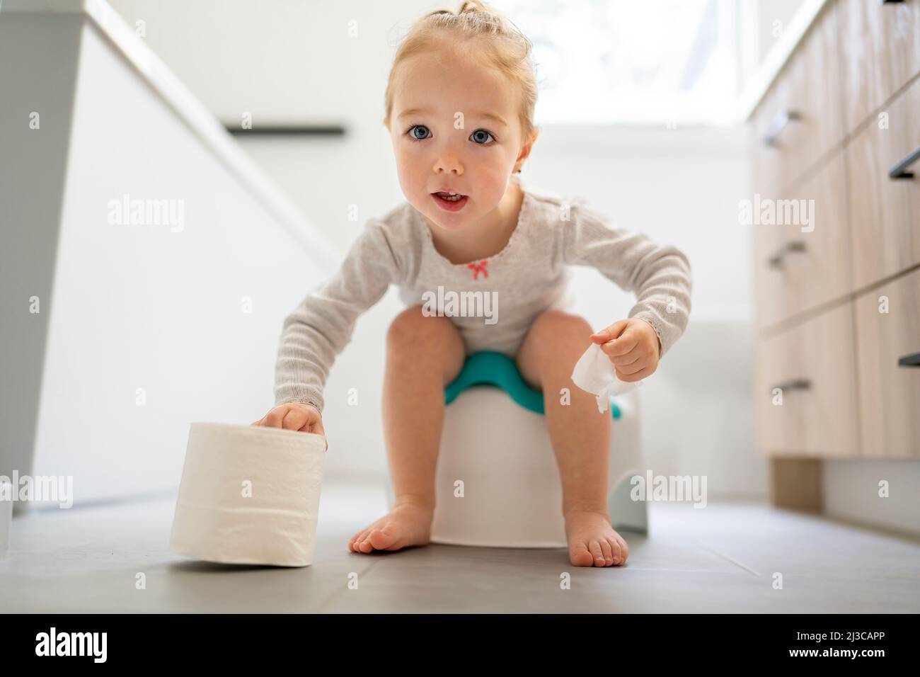 Adorable young baby child sitting and learning how to use the toilet ...