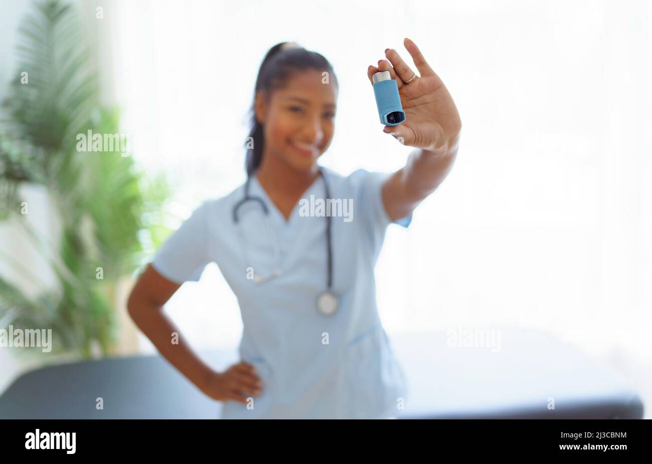 Young doctor holding asthma inhaler in clinic Stock Photo - Alamy