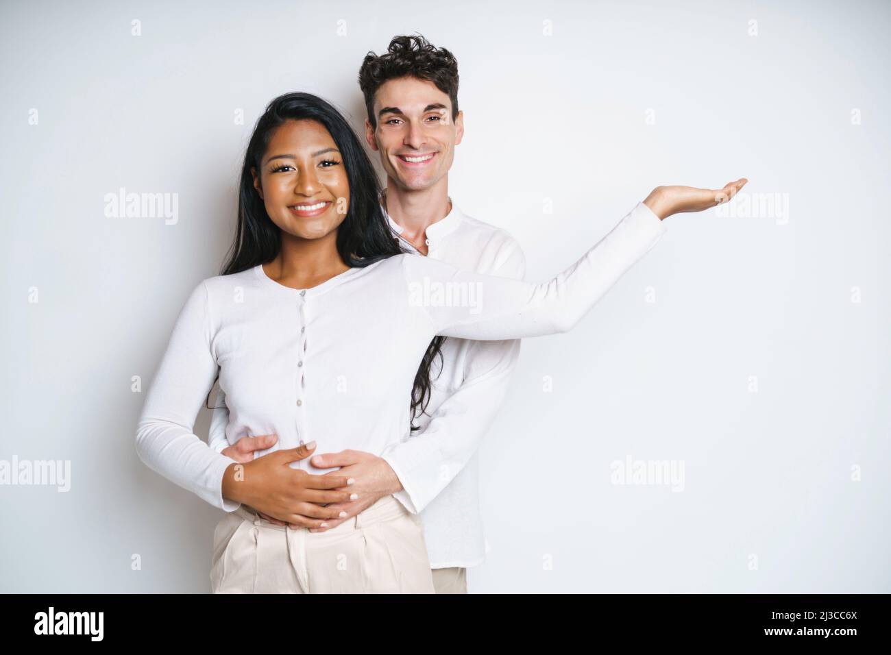 young couple standing together posing in studio white background with ...