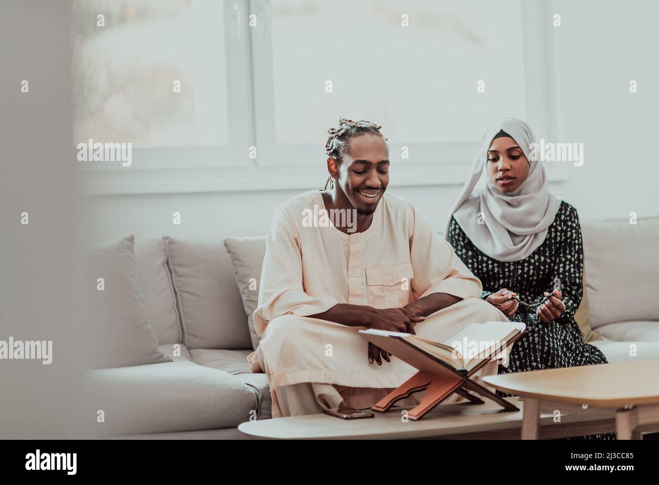 African Muslim couple at home in Ramadan reading Quran holly Islam book ...