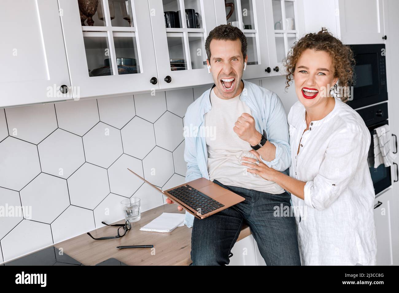 Image of successful young couple man and woman working on laptops ...