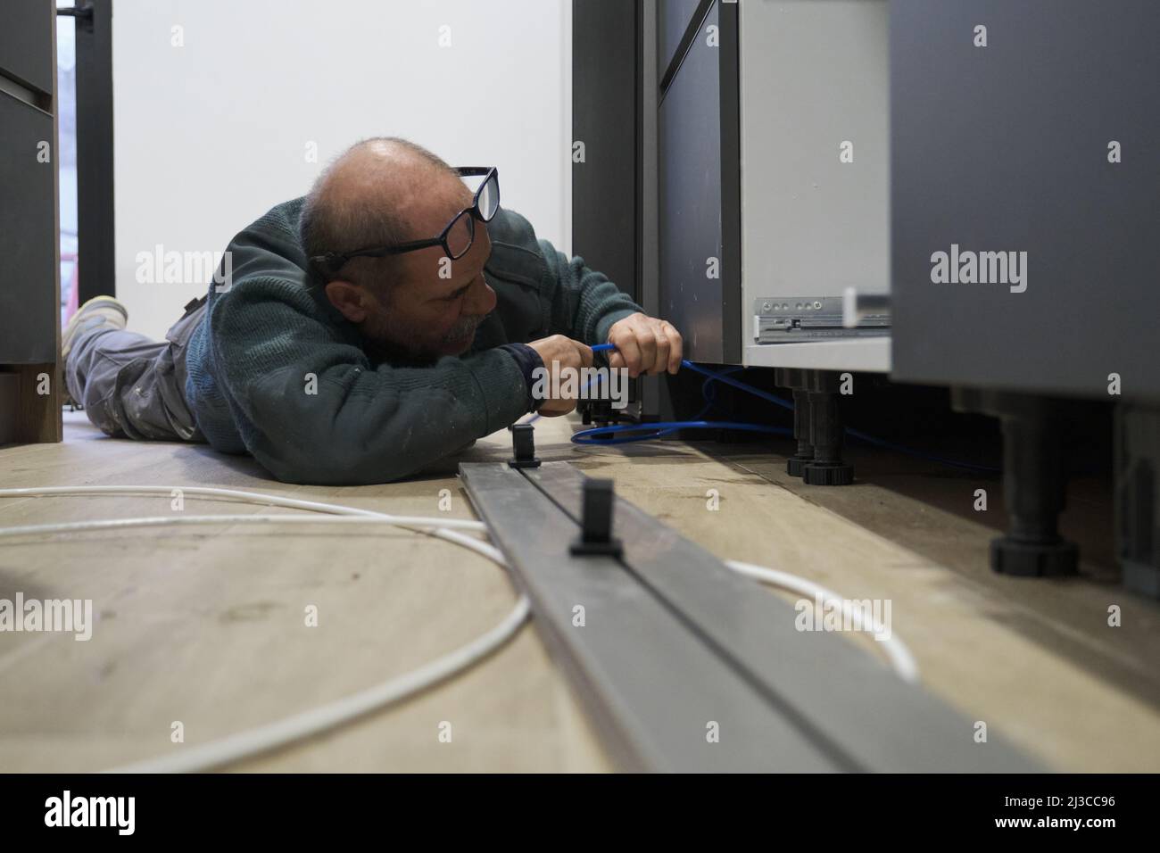 Technician install plastic tubes to connect water filter to american ...