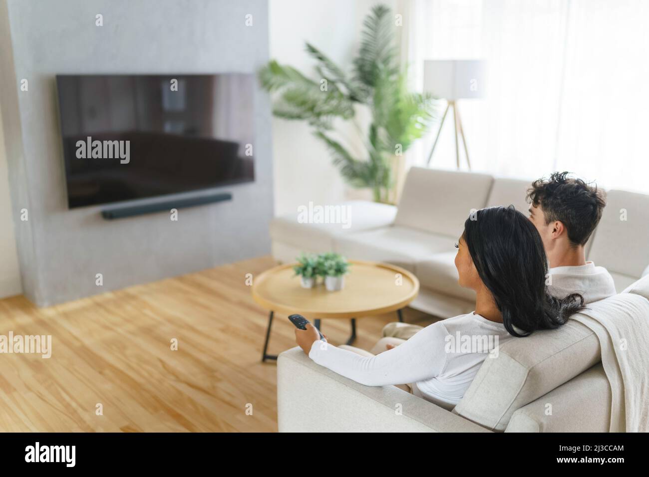 Couple watching tv in their living room at home Stock Photo - Alamy