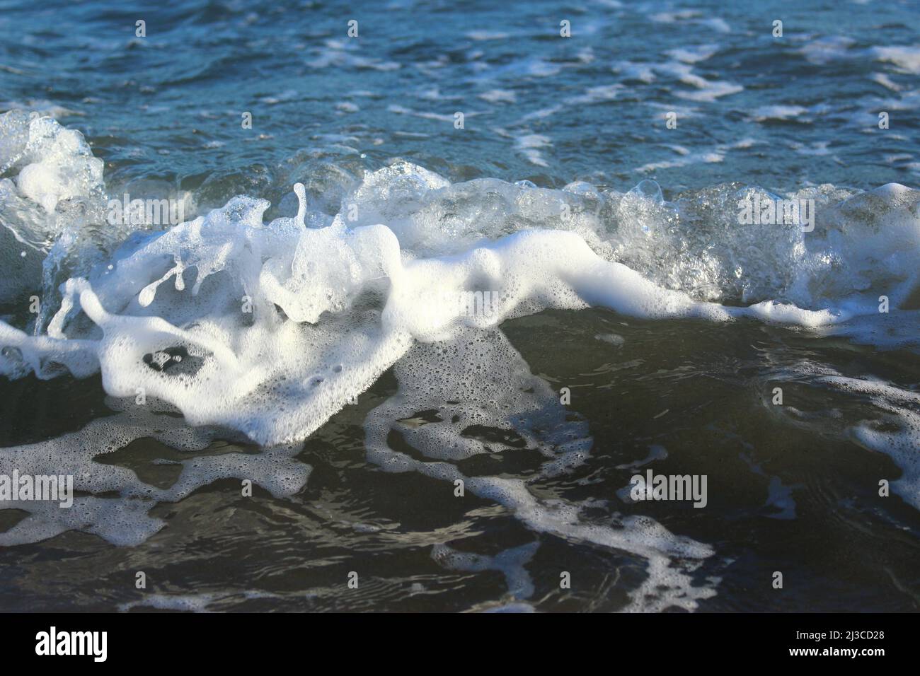 Top of a white wave coming into shore in the Mediterranean against a ...