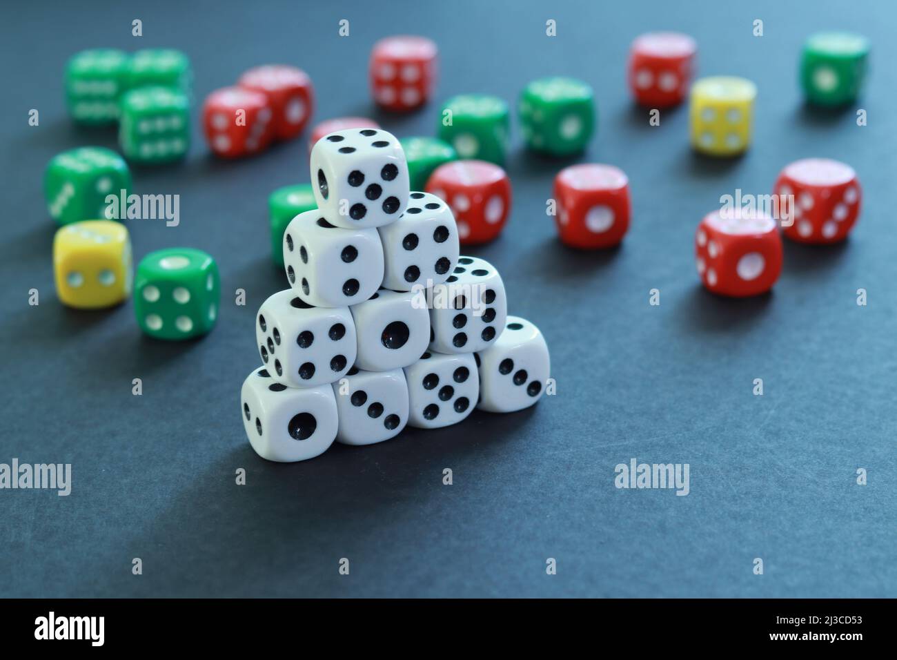 Playing dice mounted in a pyramid and others of several colors in the ...
