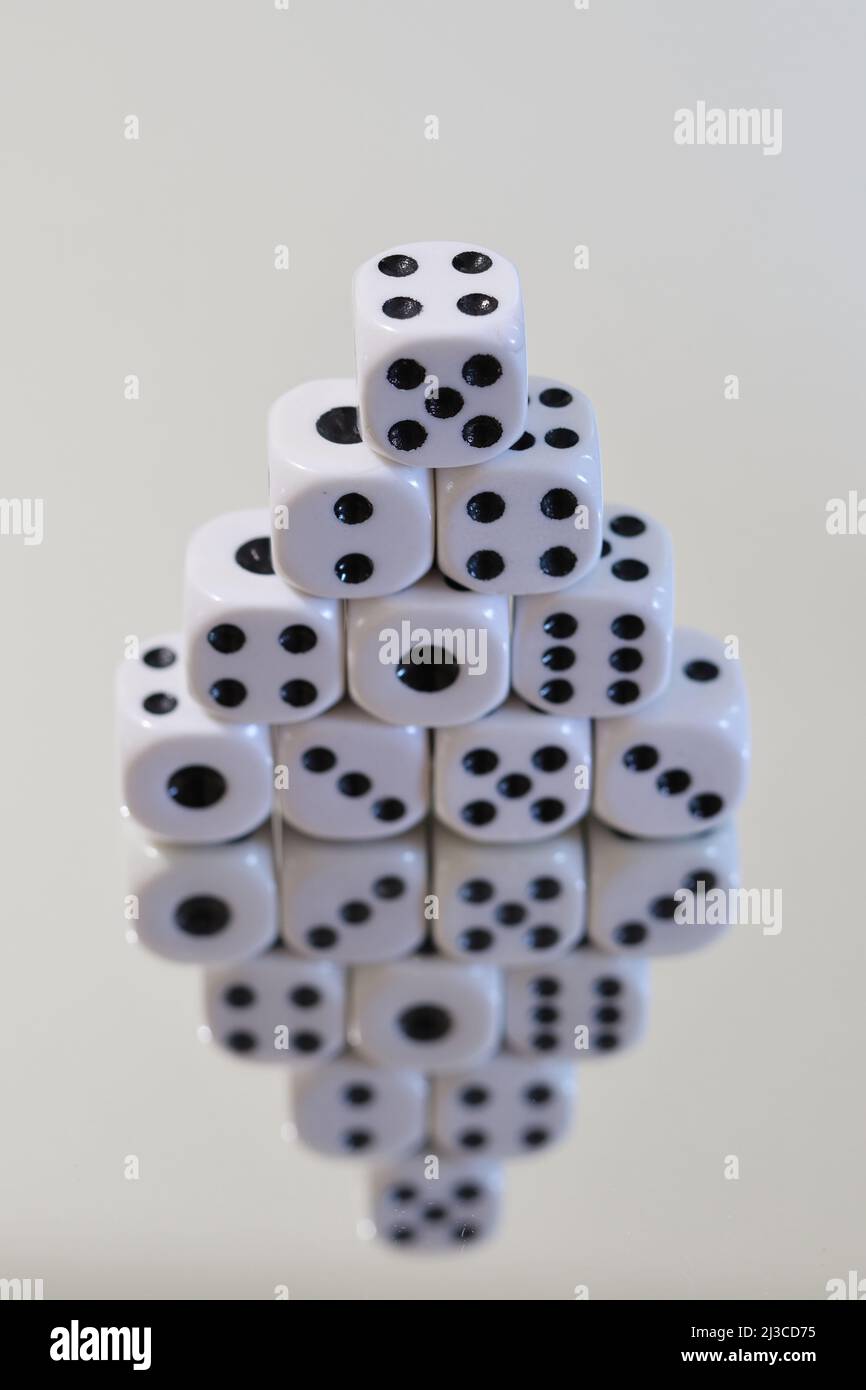 Playing dice mounted in a pyramid with reflection on a mirror Stock ...