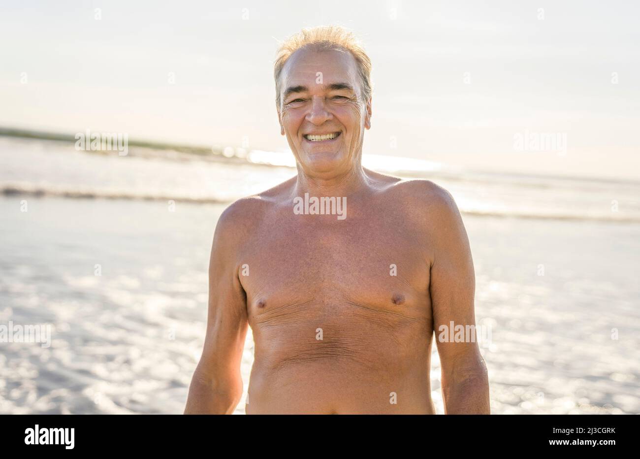 Senior men having great time on beach at the sunset Stock Photo - Alamy
