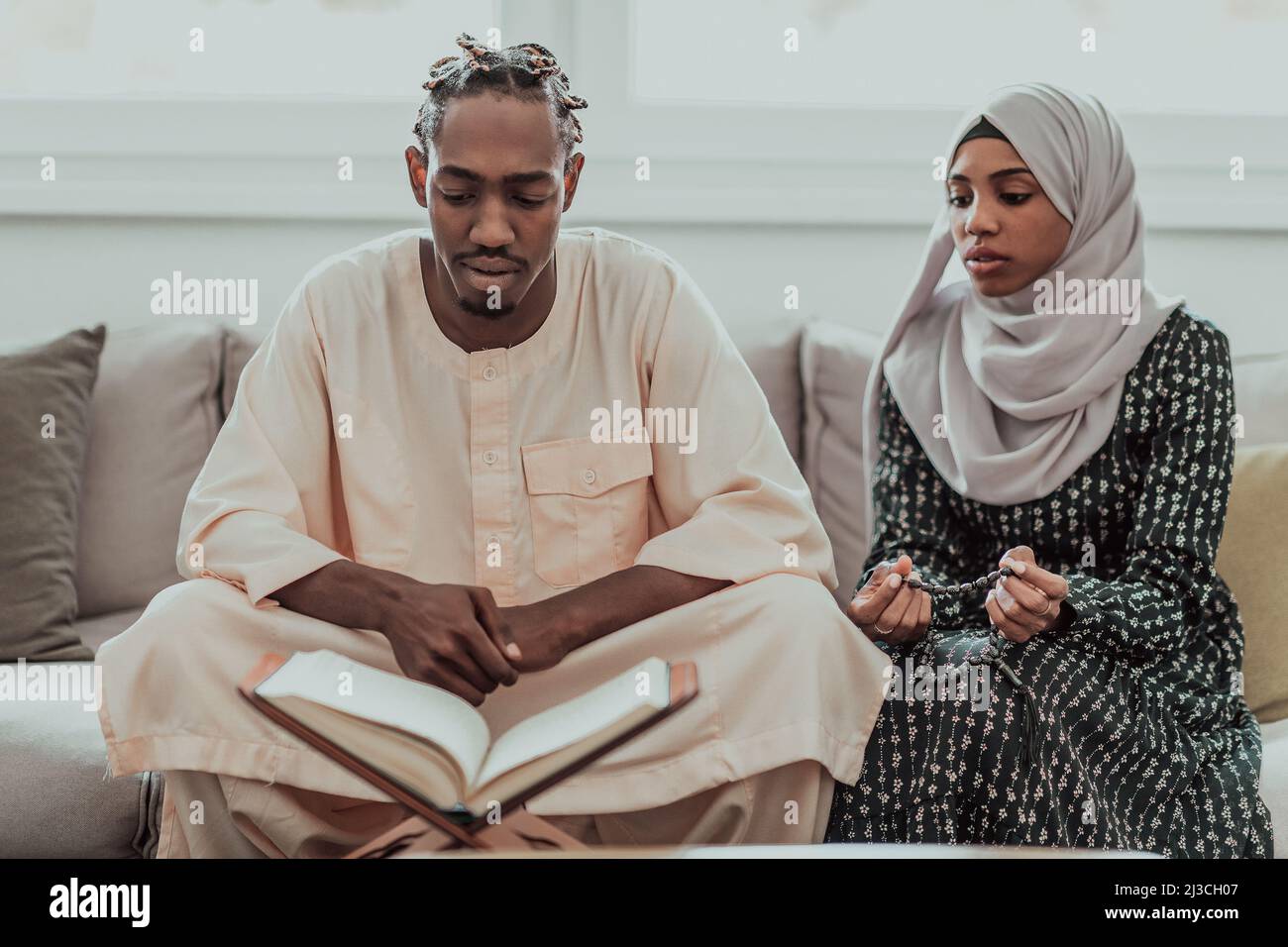 African Muslim couple at home in Ramadan reading Quran holly Islam book ...